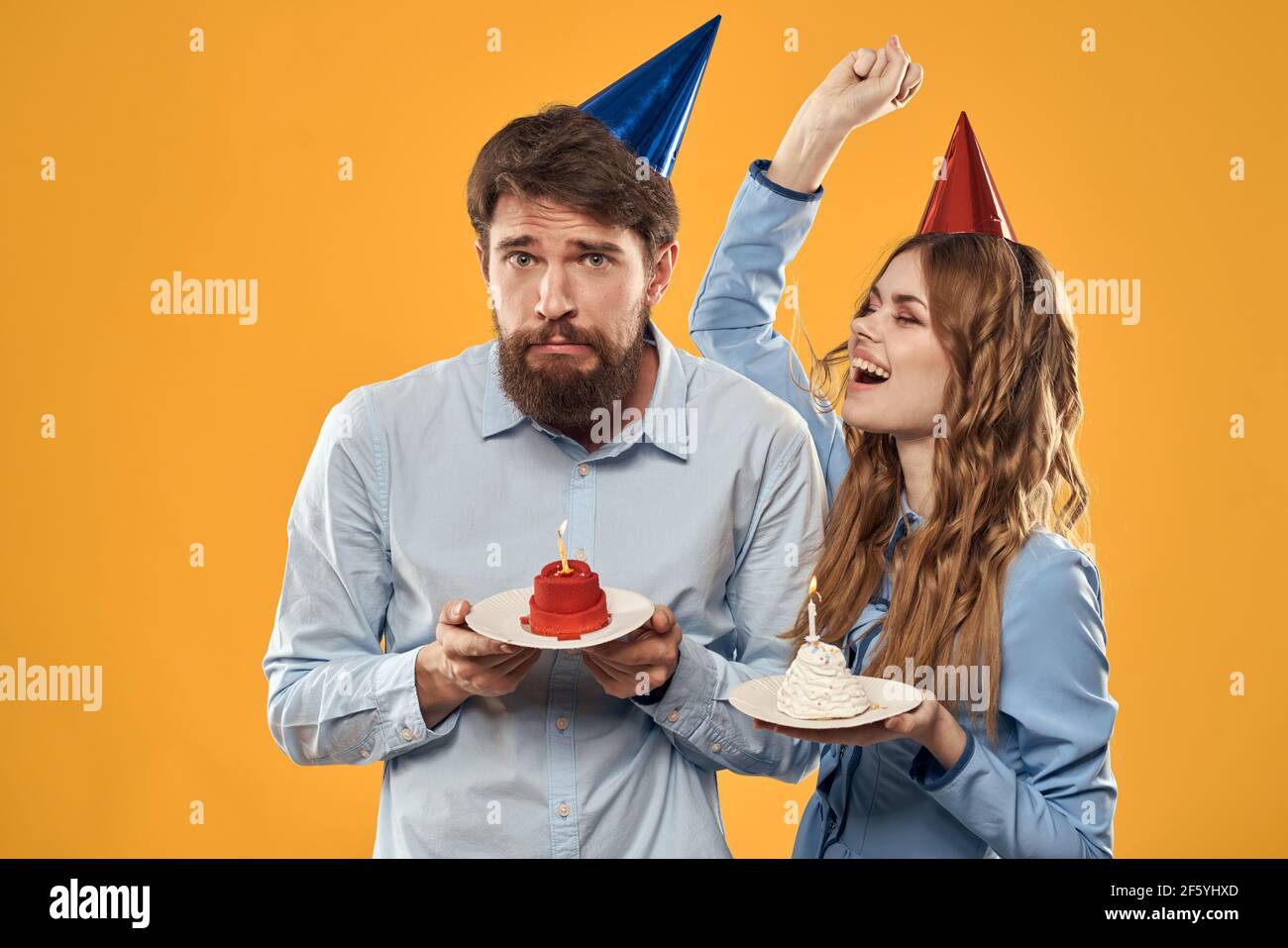 Birthday party man and woman in a cap with a cake on a yellow ...
