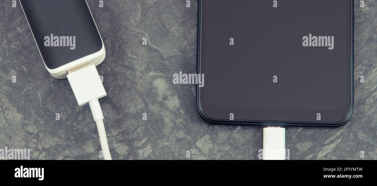External black powerbank charging empty battery of smartphone or mobile ...