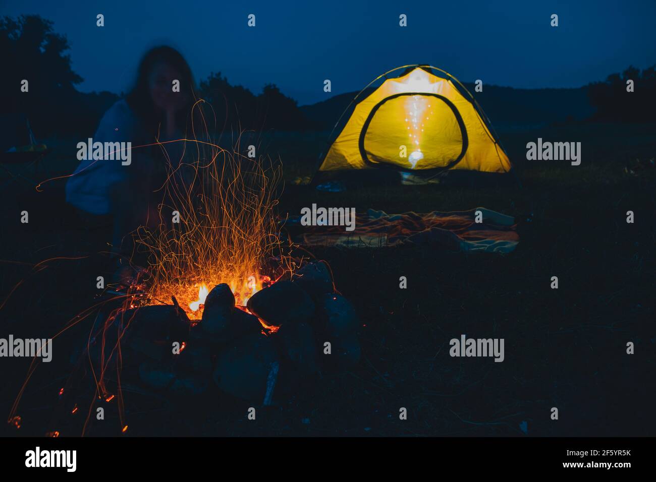 long exposure bonfire with yellow tent on background. copy space Stock ...