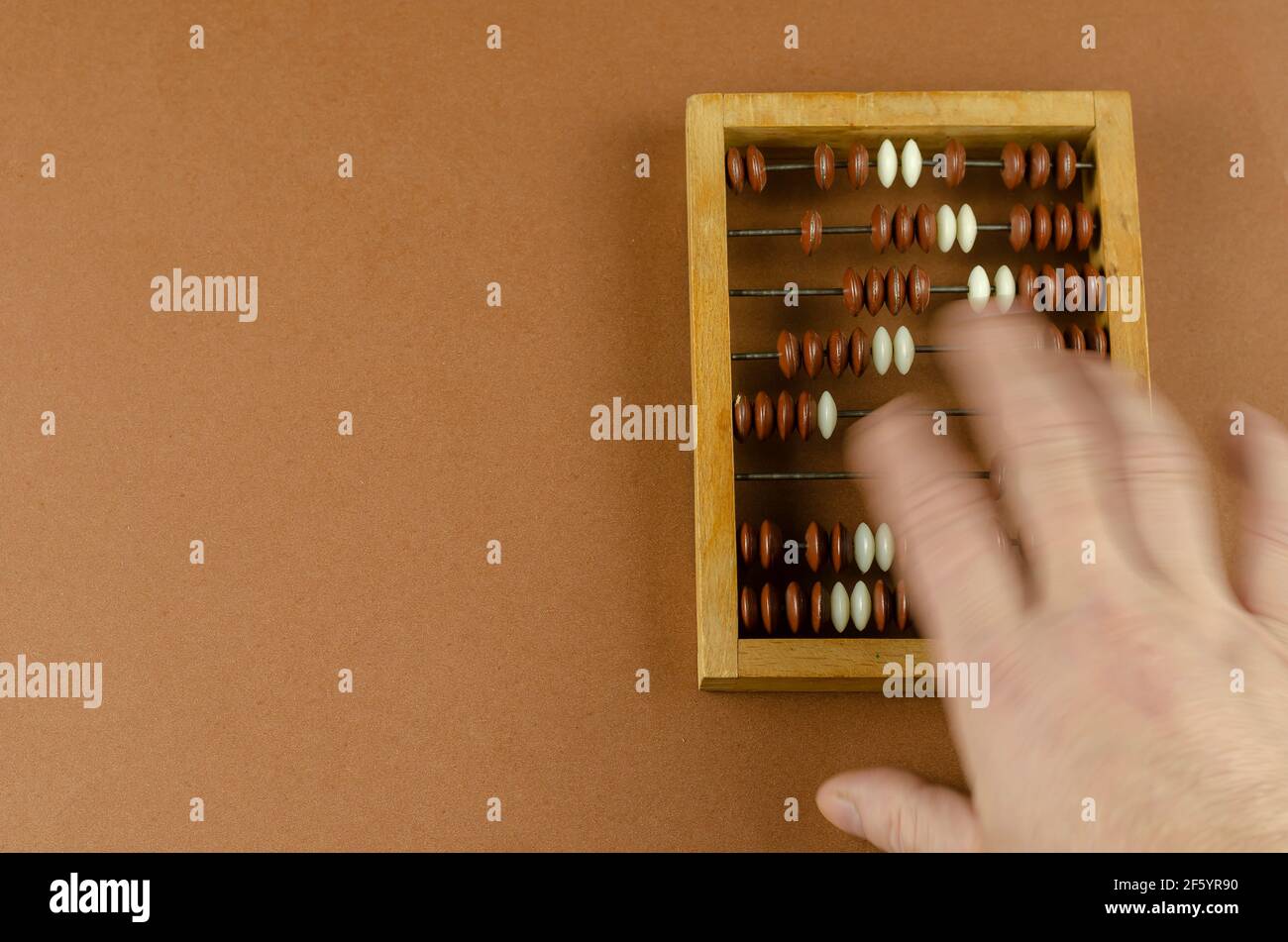 Blurred motion of the hand counting on wooden abacus. Right male hand ...