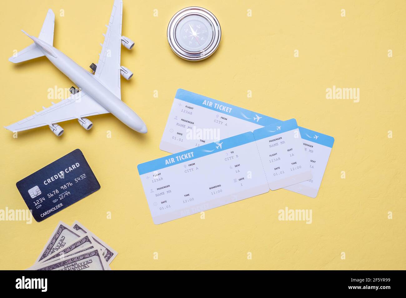 Plane, airline tickets, money and compass on a yellow background ...