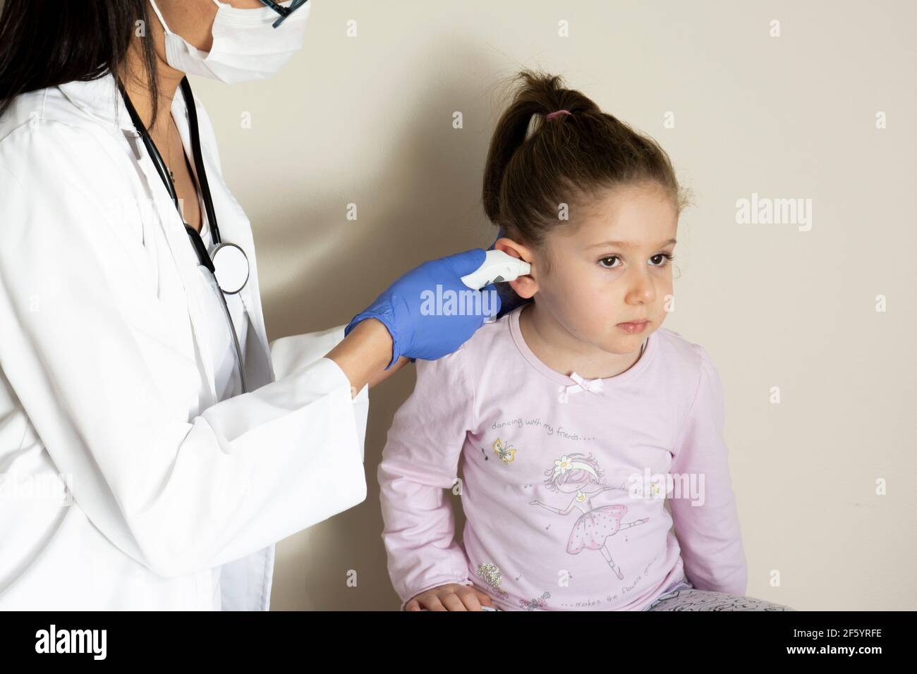 chubby little girl in pediatric examination by her doctor. ENT ( Ear ...