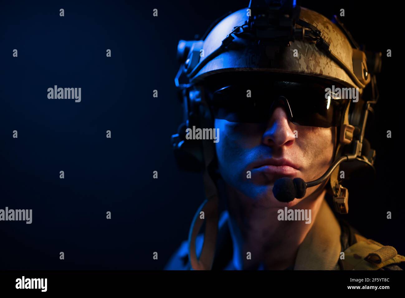 Portrait of special forces soldier in helmet and glasses in the dark ...
