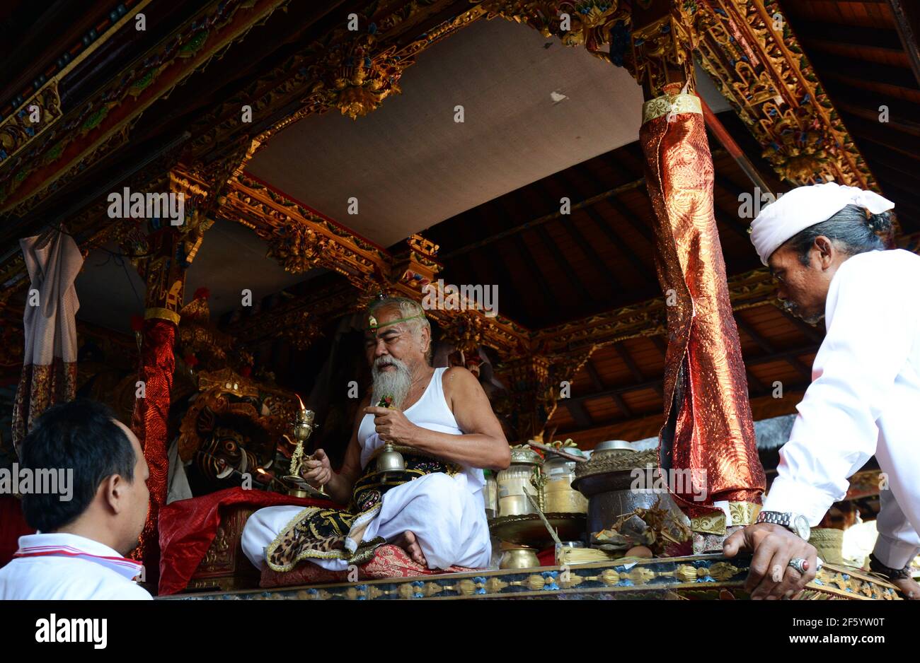 A Balinese Hindu priest blessing a groom in a pre wedding ceremony in a ...