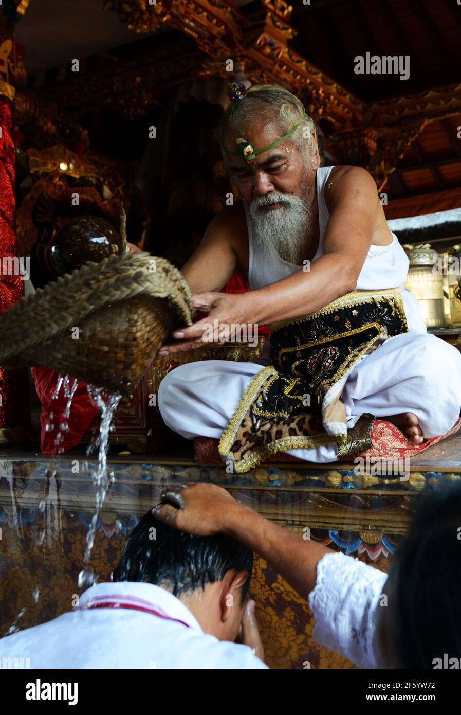 A Balinese Hindu priest blessing a groom in a pre wedding ceremony in a ...