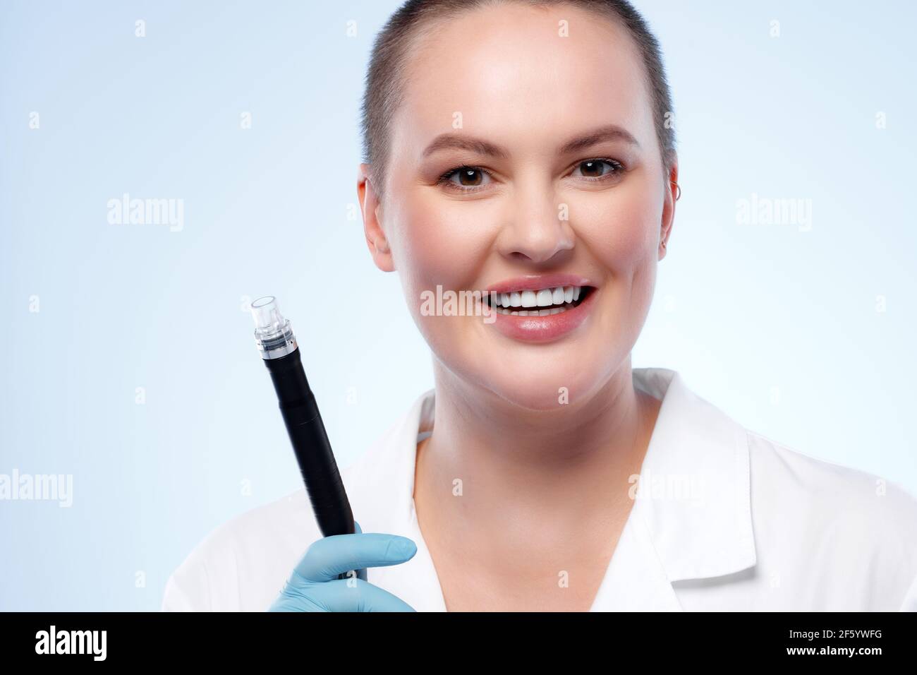 Portrait of a woman dermatologist holding cosmetic device attachment ...