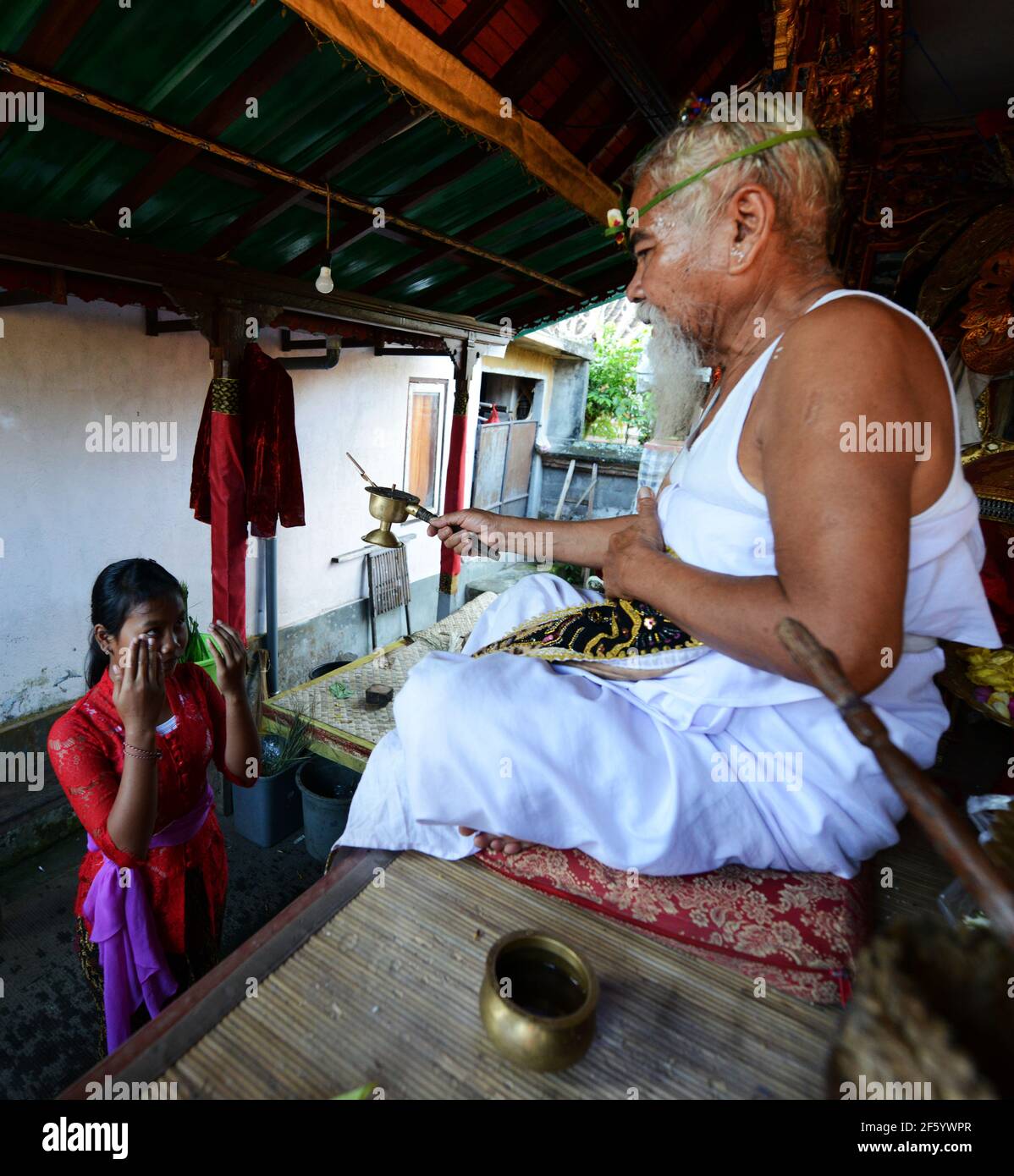 A Balinese Hindu priest blessing a groom in a pre wedding ceremony in a ...