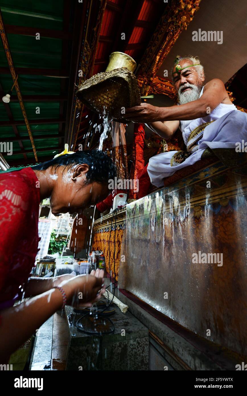 A Balinese Hindu priest blessing a groom in a pre wedding ceremony in a ...