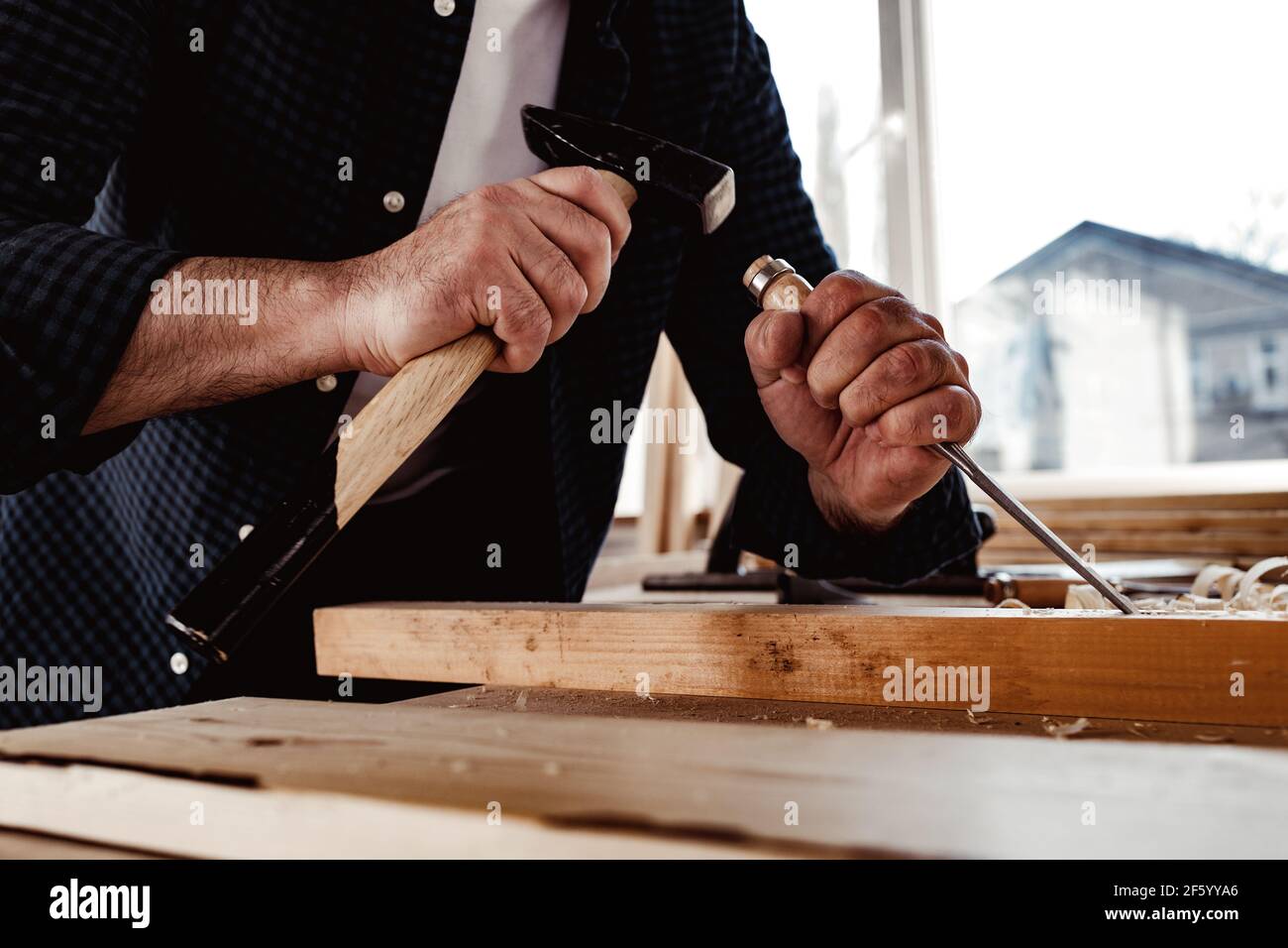 Hands of a carpenter working with chisel and hammer Stock Photo - Alamy
