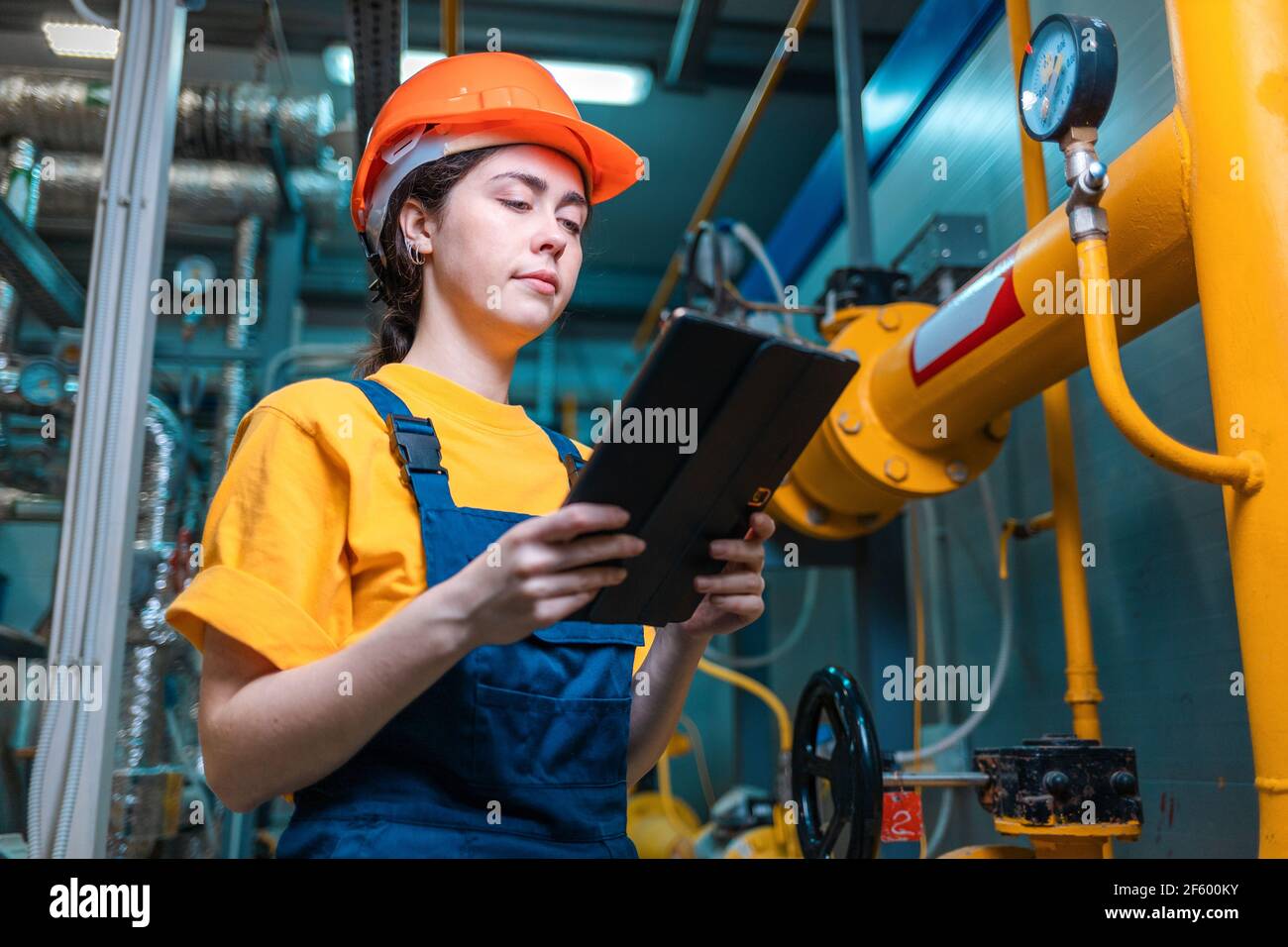 Production inspection. A young engineer in a uniform and a protective ...