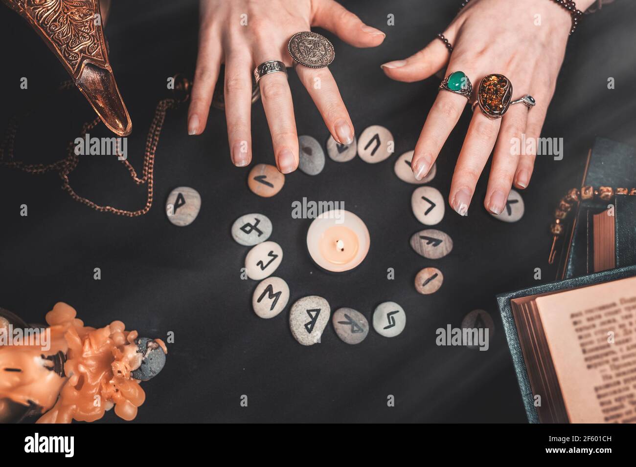 Astrology and esotericism. Female witch hands conjure over the rune ...