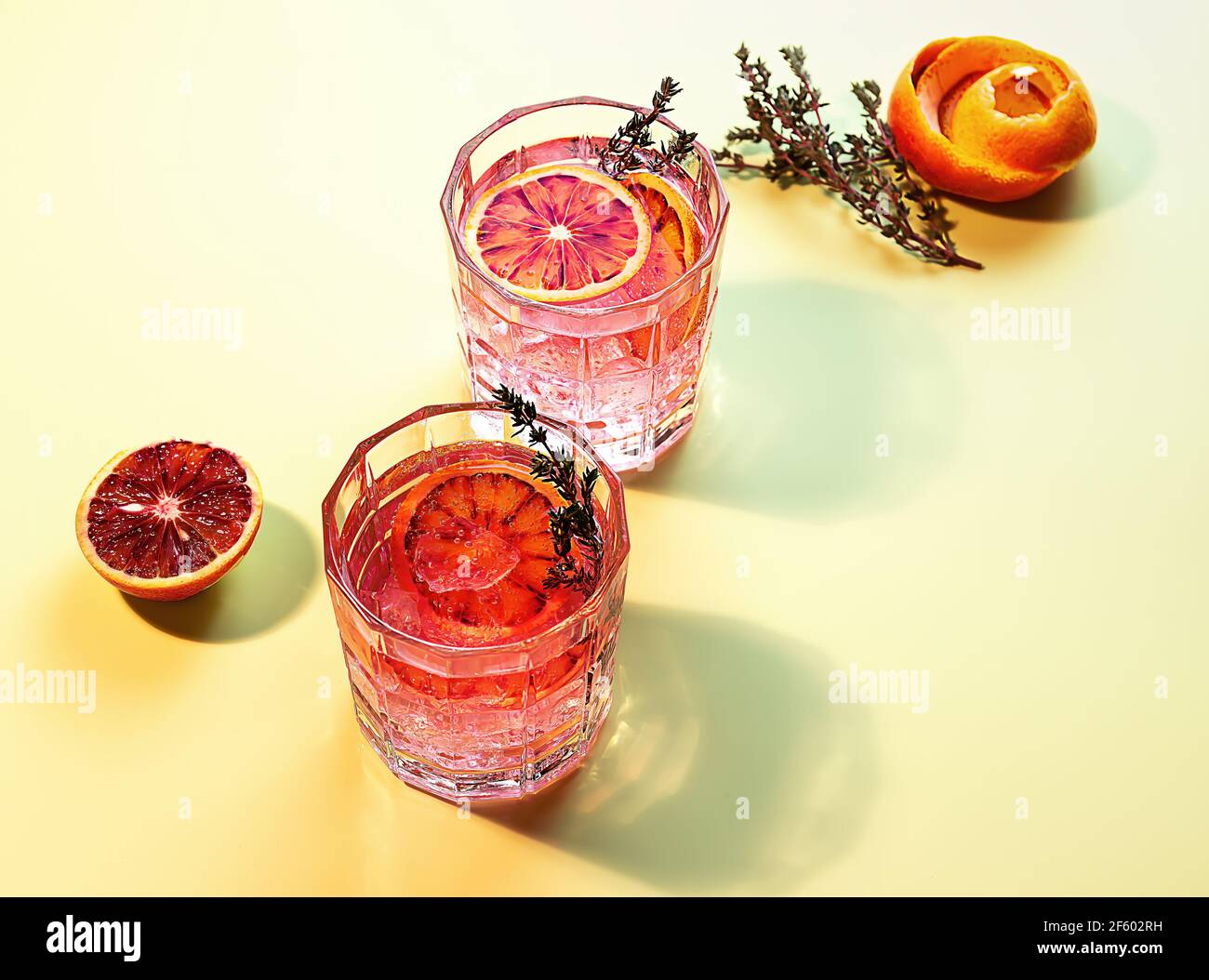 Pink gin cocktail with red blood orange and ice in sunny day. Trendy ...