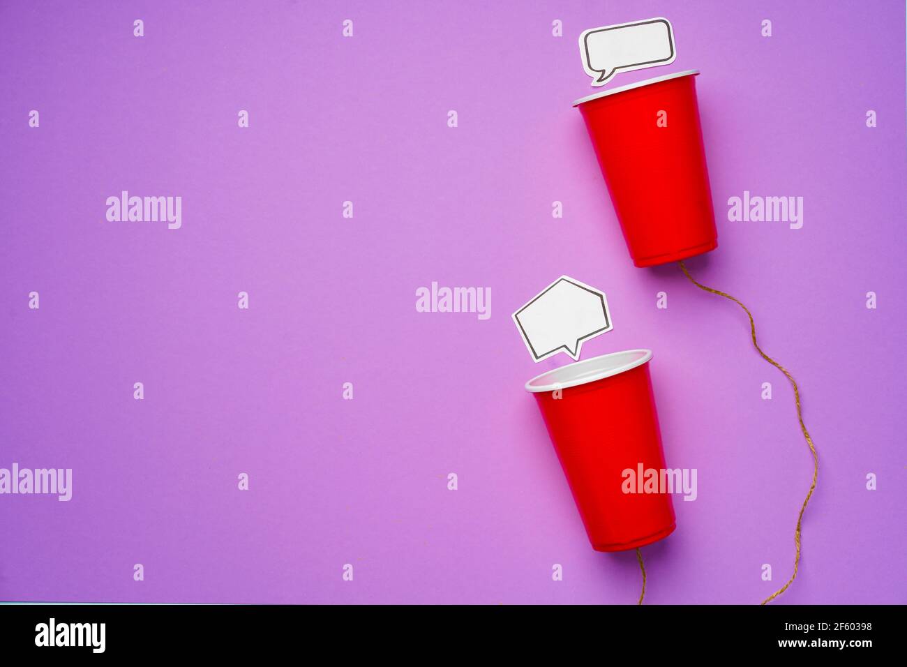 Toy telephone made of plastic cups and string with speech bubbles on ...