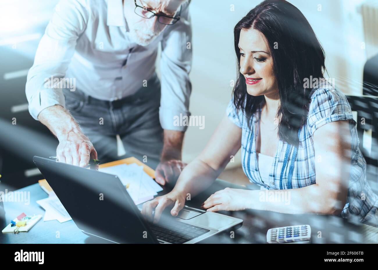 Young businesswoman and senior businessman working together at office ...