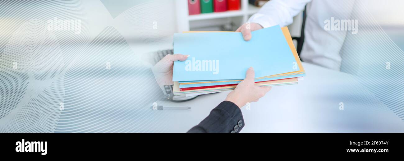 Secretary putting files in the hand of a businessman at the office ...