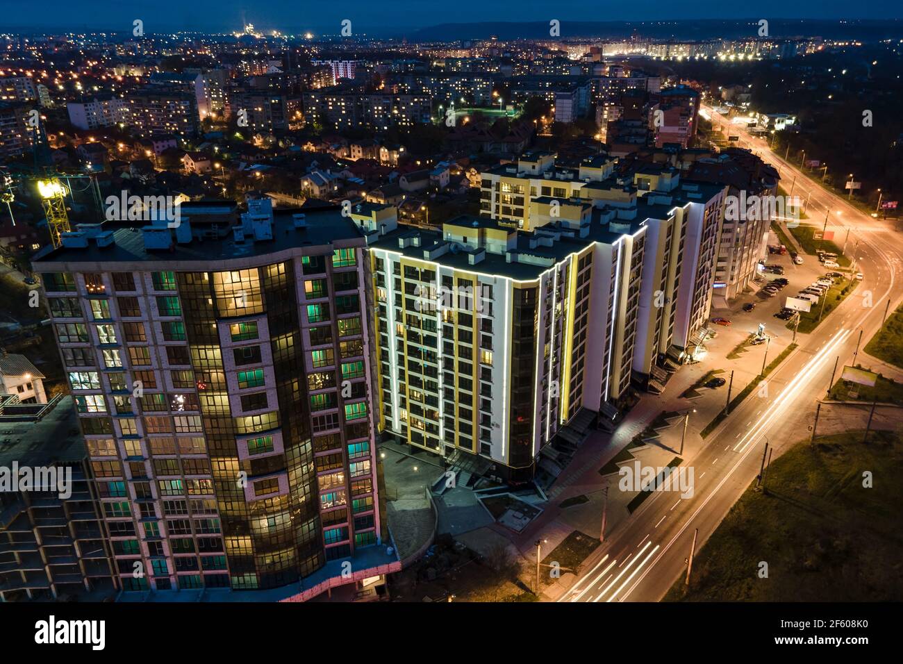 High rise apartment buildings with illuminated windows in city ...