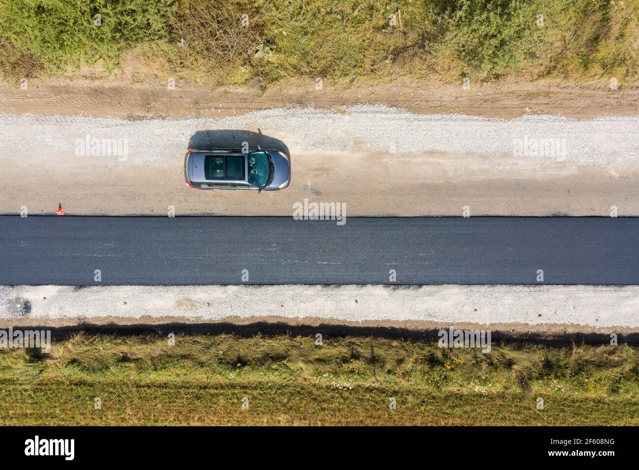 Aerial view of new road construction with newly layed black asphalt ...