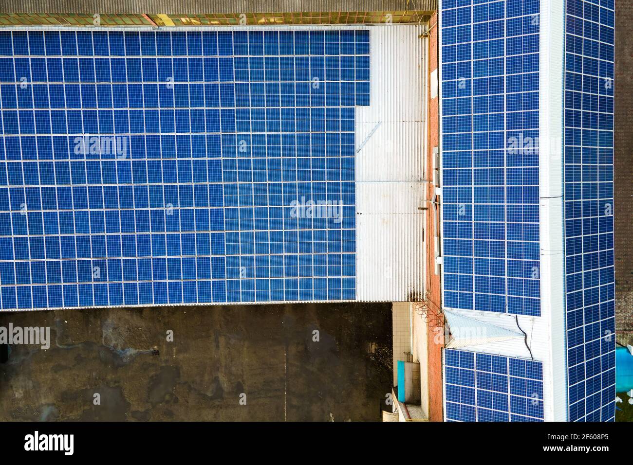 Blue photovoltaic solar panels mounted on industrial building roof for ...