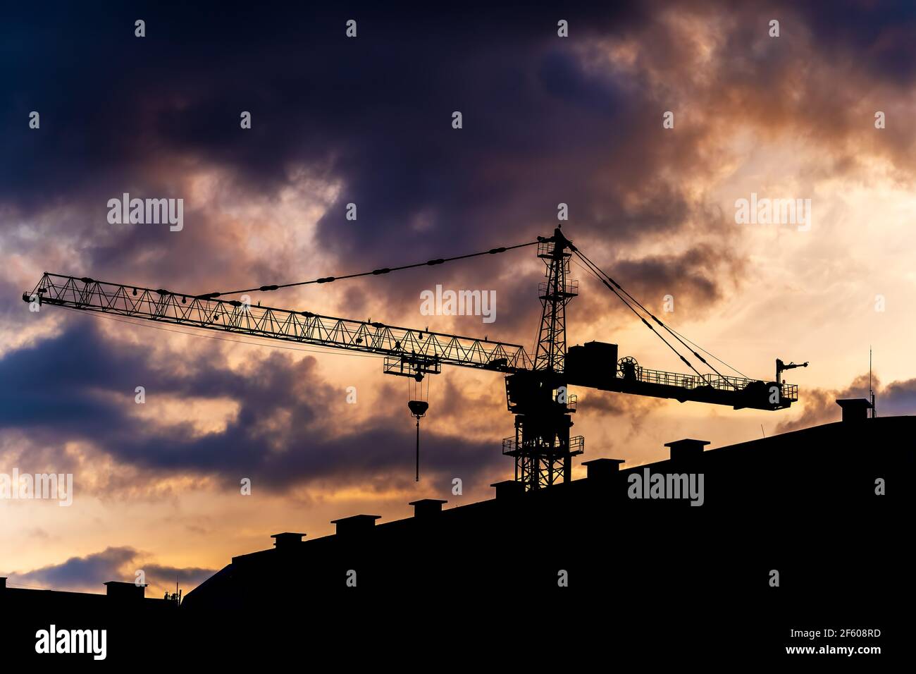 Silhouette of Industrial construction crane and building at sunset ...