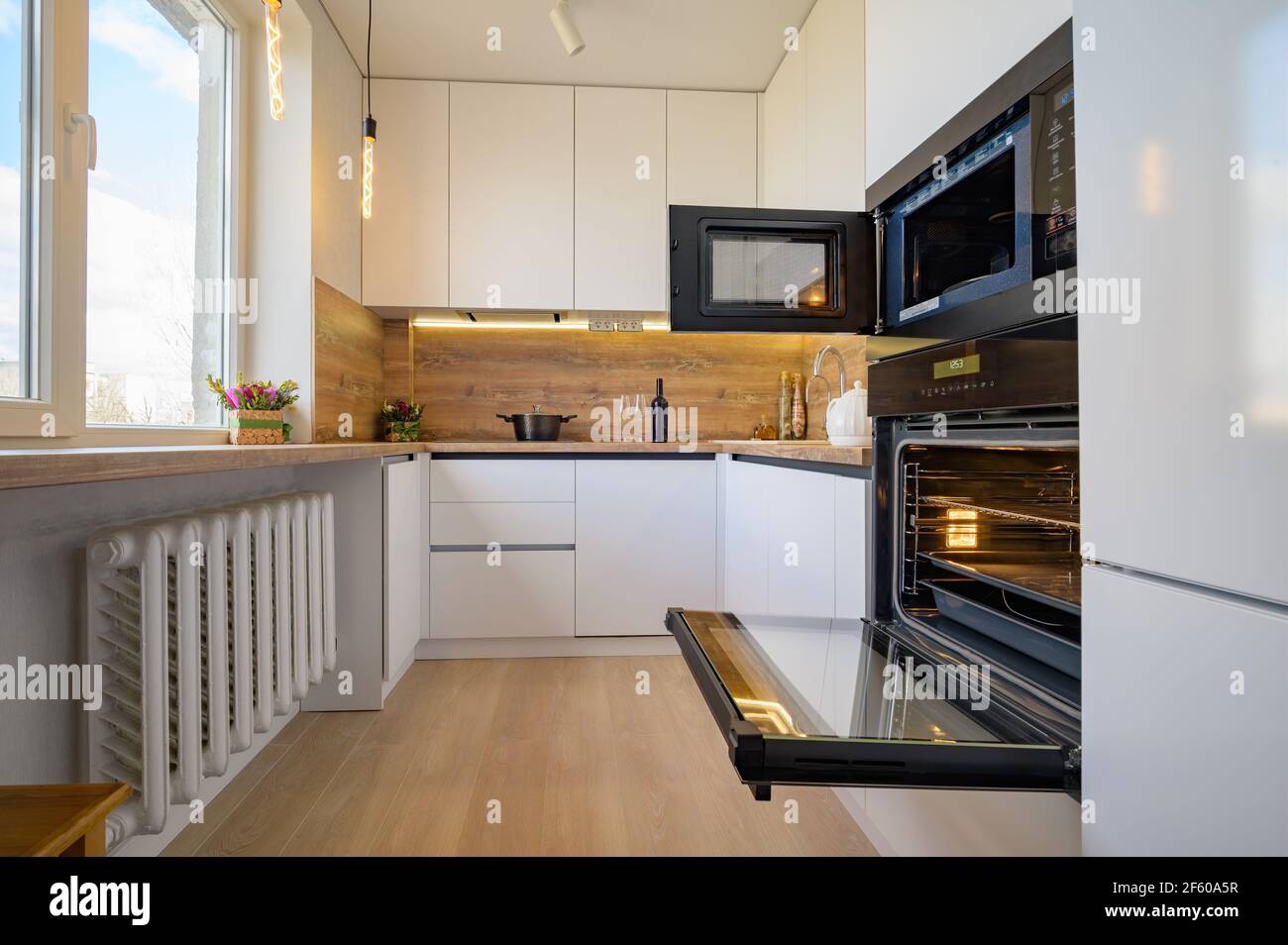 Modern white and beige wooden kitchen interior with oven opened Stock ...