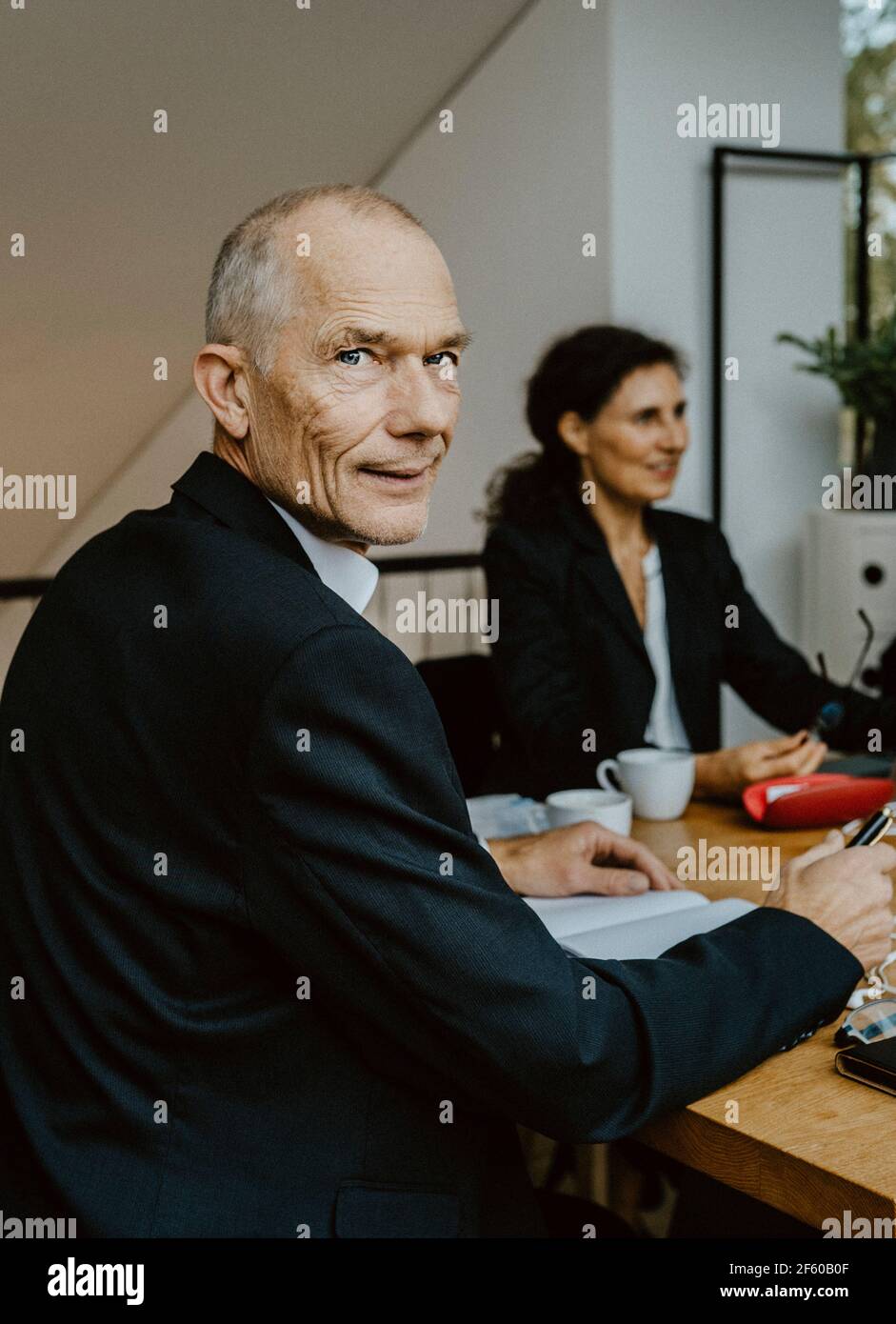 Portrait of businessman at desk in office Stock Photo - Alamy