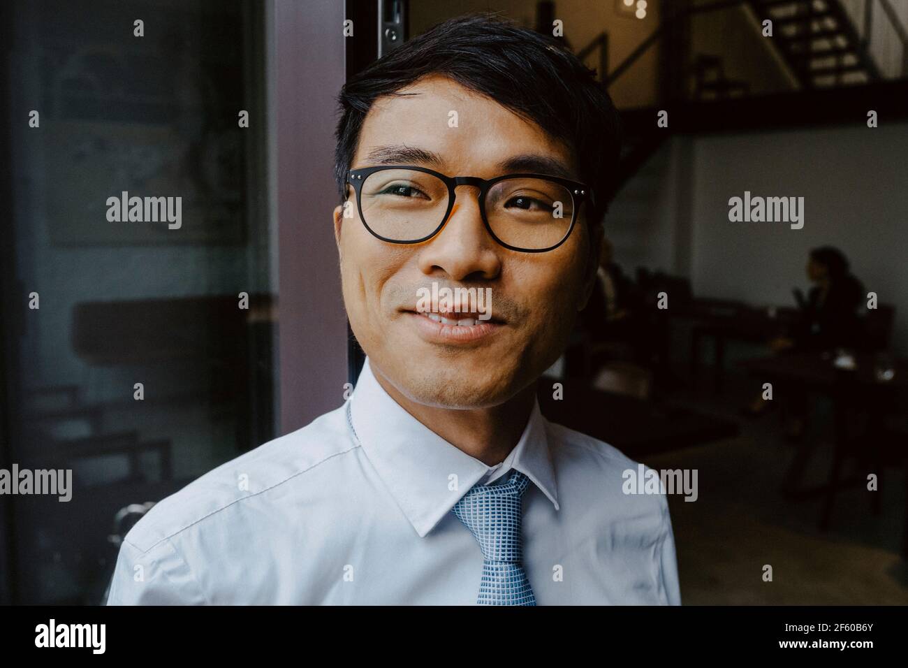 Happy male entrepreneur looking away in office Stock Photo - Alamy