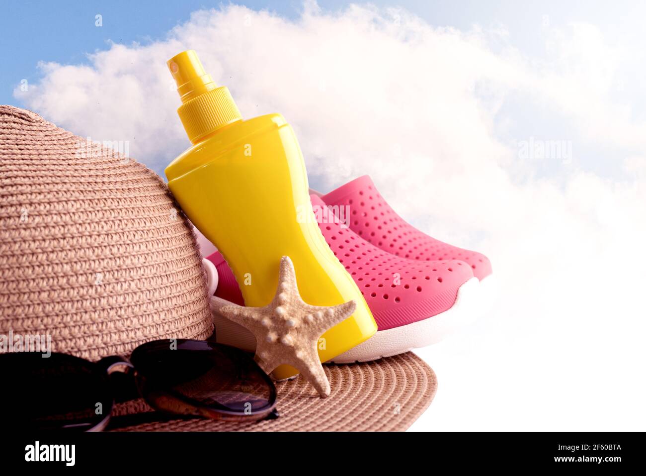 Sunscreen spray bottle and summer straw hat beach shoes and sunglasses ...