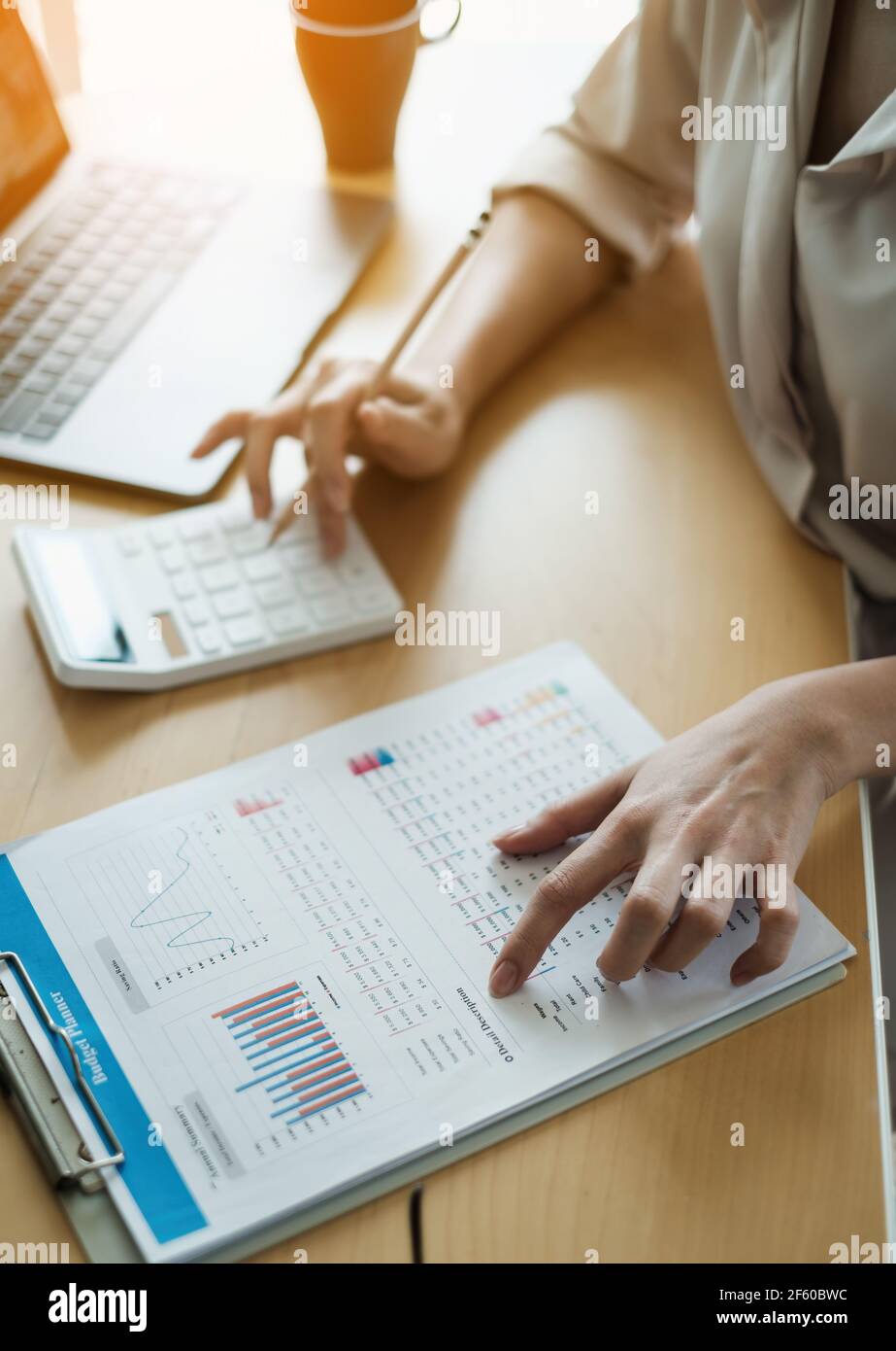 Business woman using a calculator to calculate working on desk in home ...