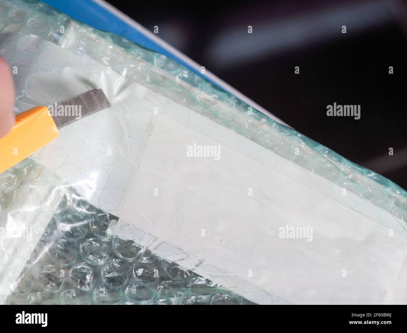 unpacking a box with the help of a cutter Stock Photo - Alamy