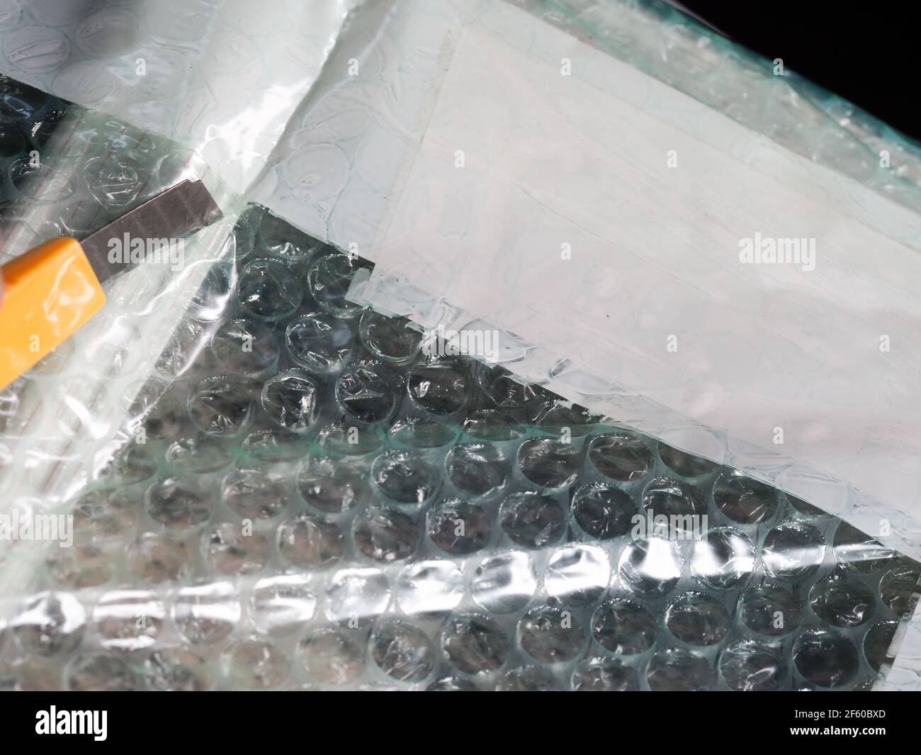 unpacking a box with the help of a cutter Stock Photo - Alamy