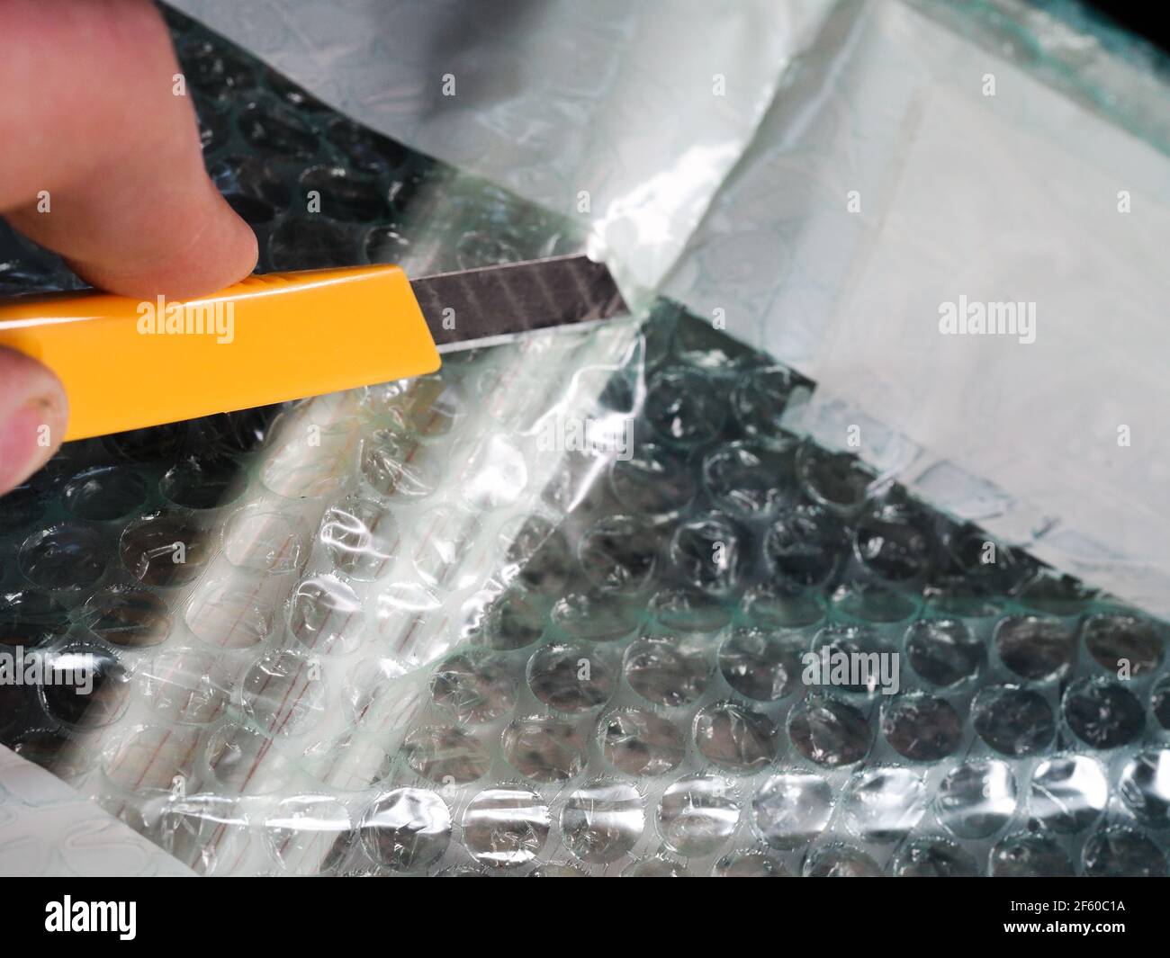 unpacking a box with the help of a cutter Stock Photo - Alamy