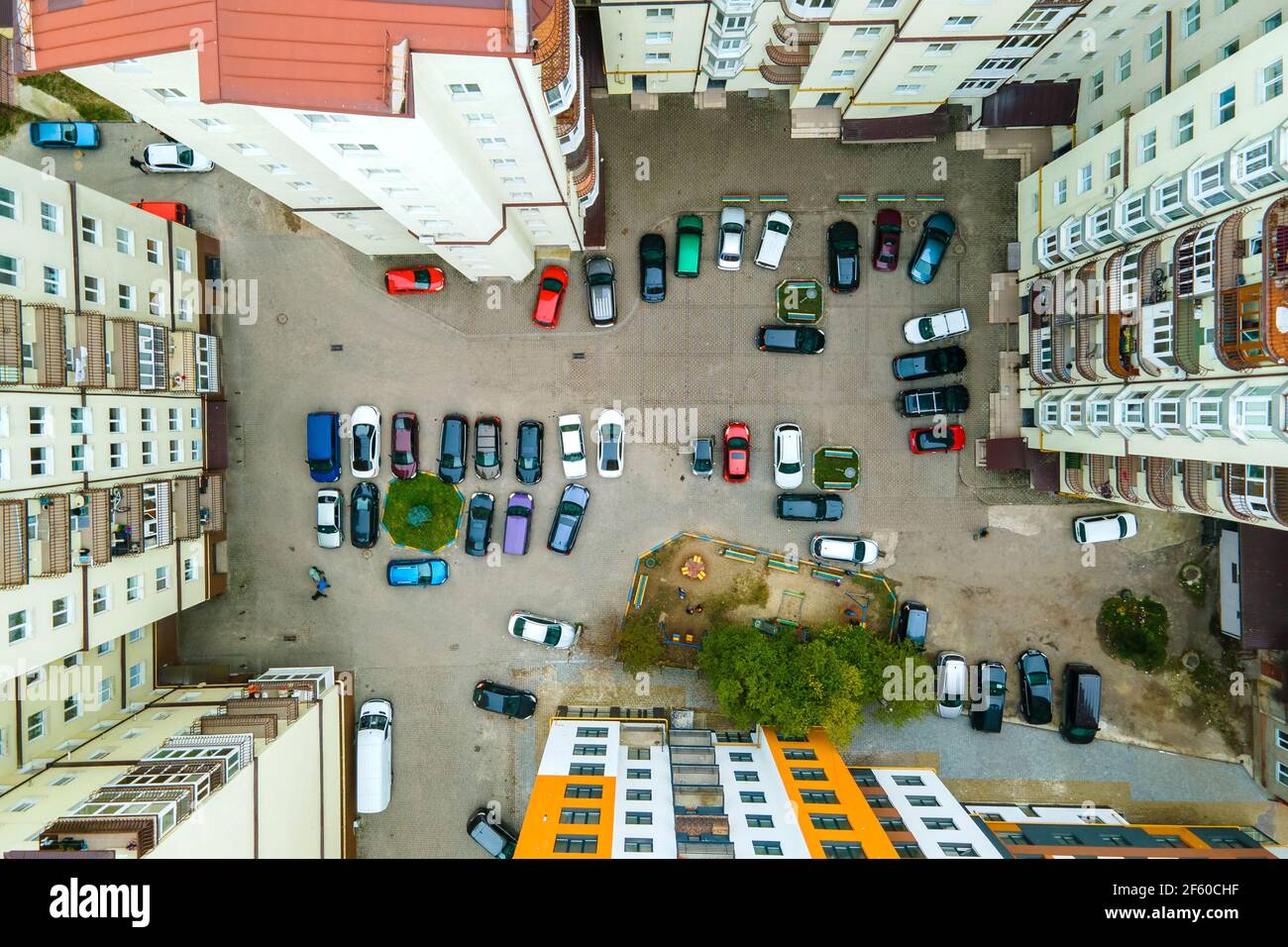 Aerial view of parked cars on parking lot between high apartment ...