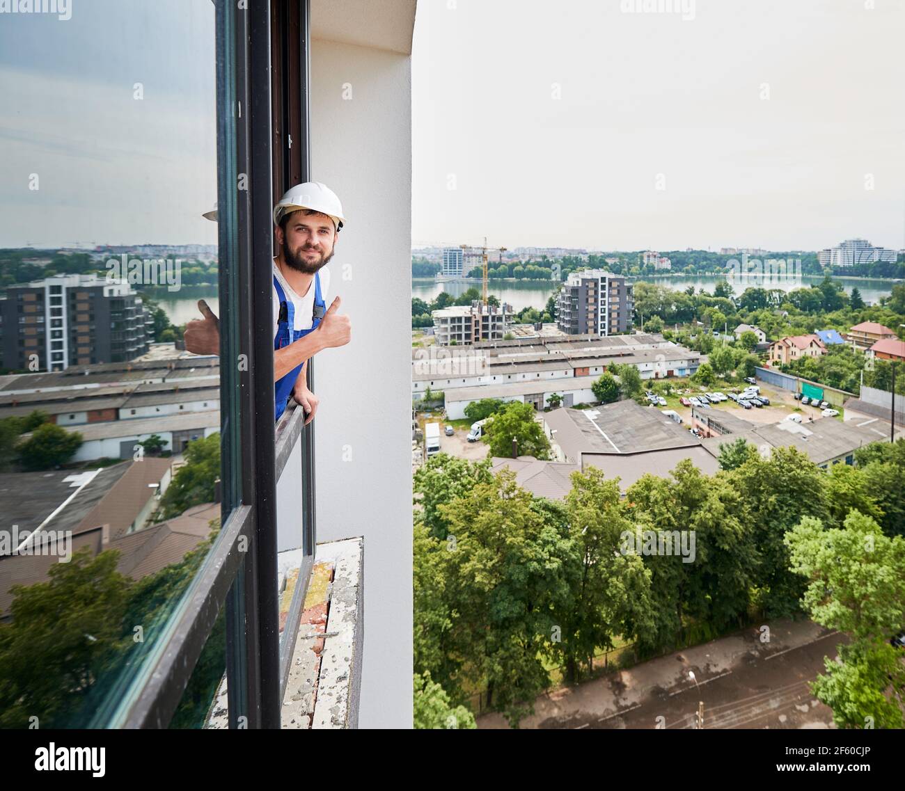 Male plumber leaning out of the window and giving thumbs up Stock Photo ...