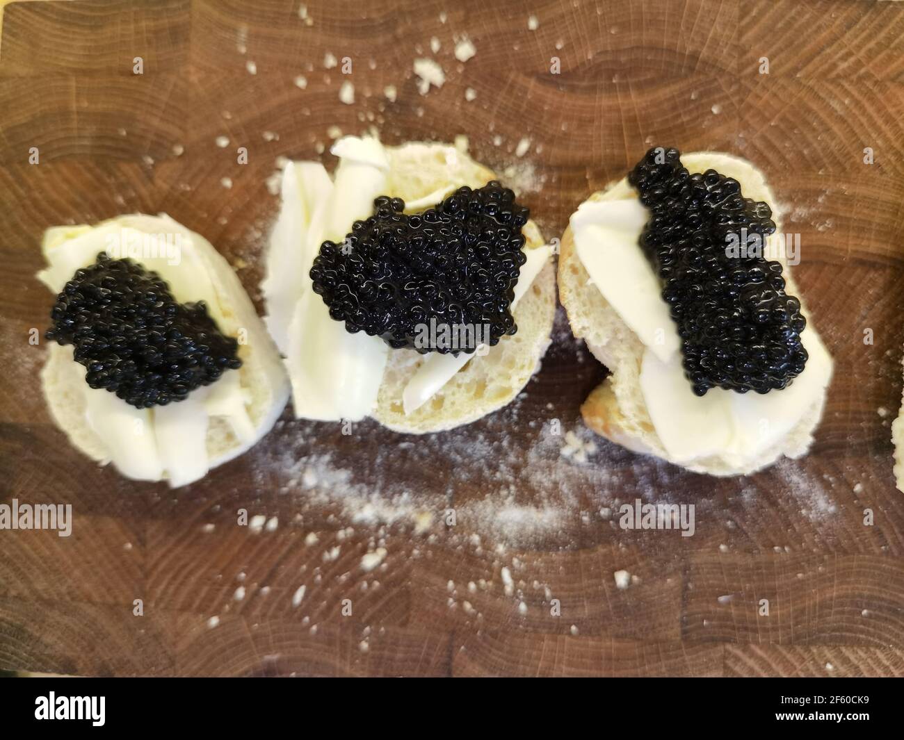 Delicious canapes with black caviar on wooden background Stock Photo ...