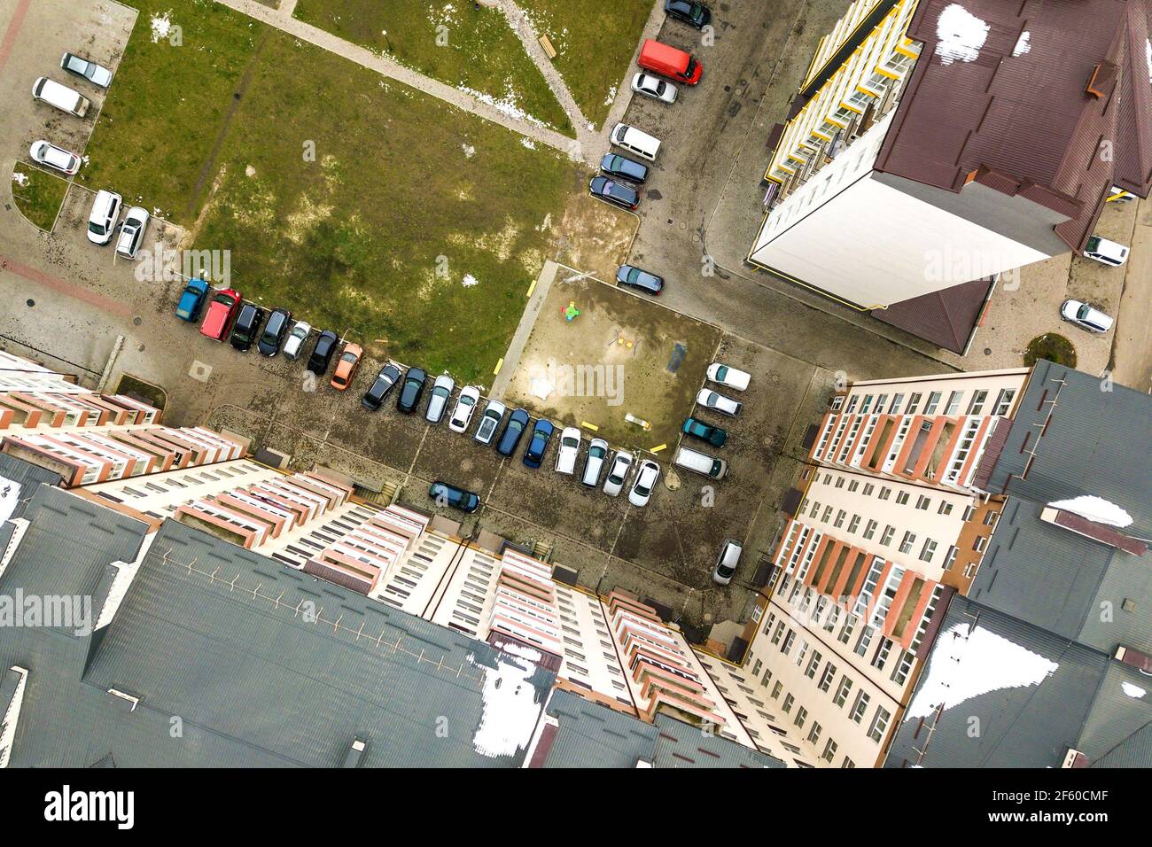 Aerial view of parked cars on parking lot between high apartment ...