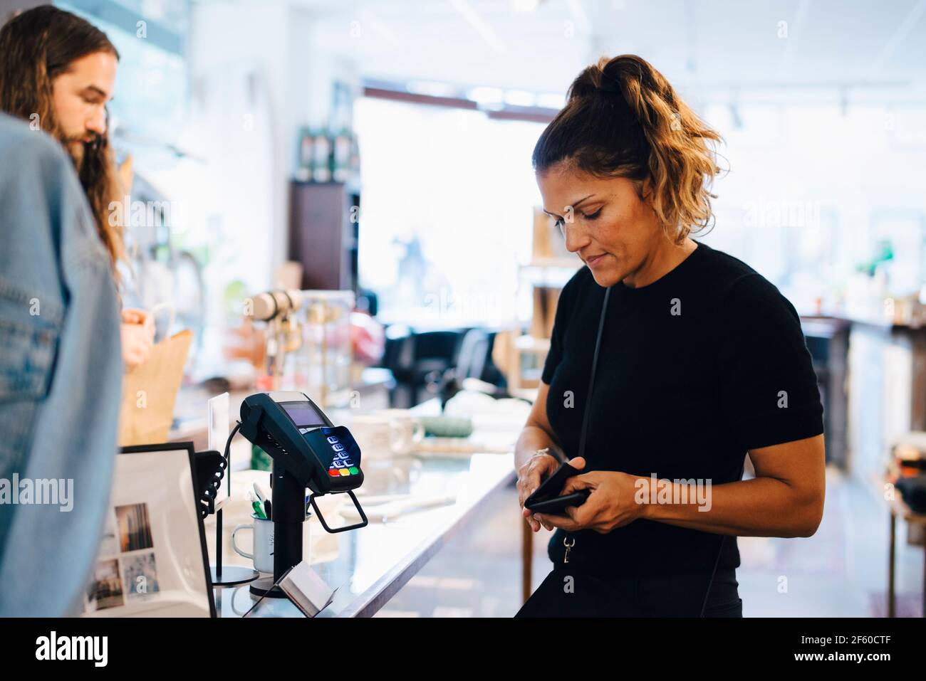 Female entrepreneur standing male by customer in retail store Stock ...