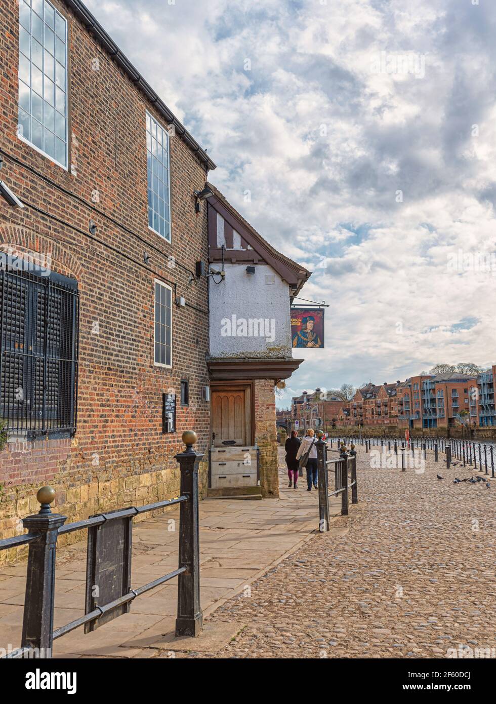 Riverside pub in York. The ancient building is beside a cobblestone ...