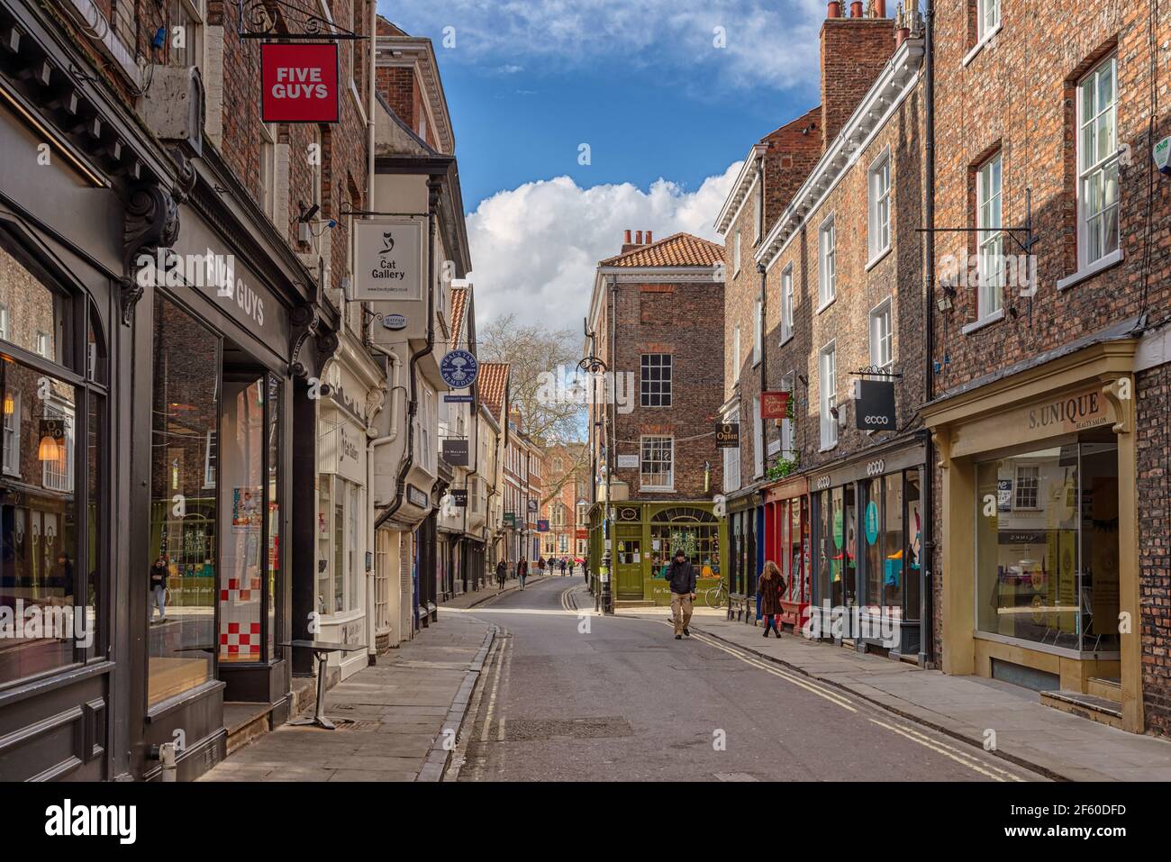 An ancient street in York. Old buildings are on each side and sunlight ...