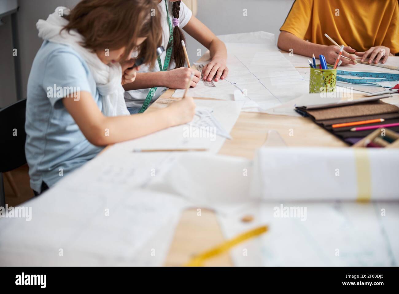 Female children drawing sewing patterns in workshop Stock Photo - Alamy