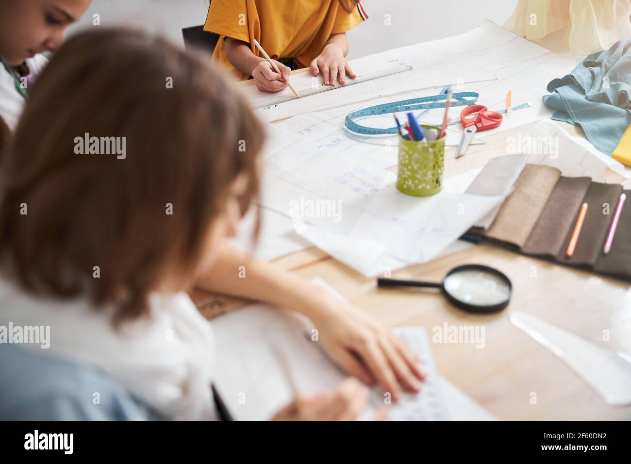 Children drawing bodice patterns in sewing workshop Stock Photo - Alamy