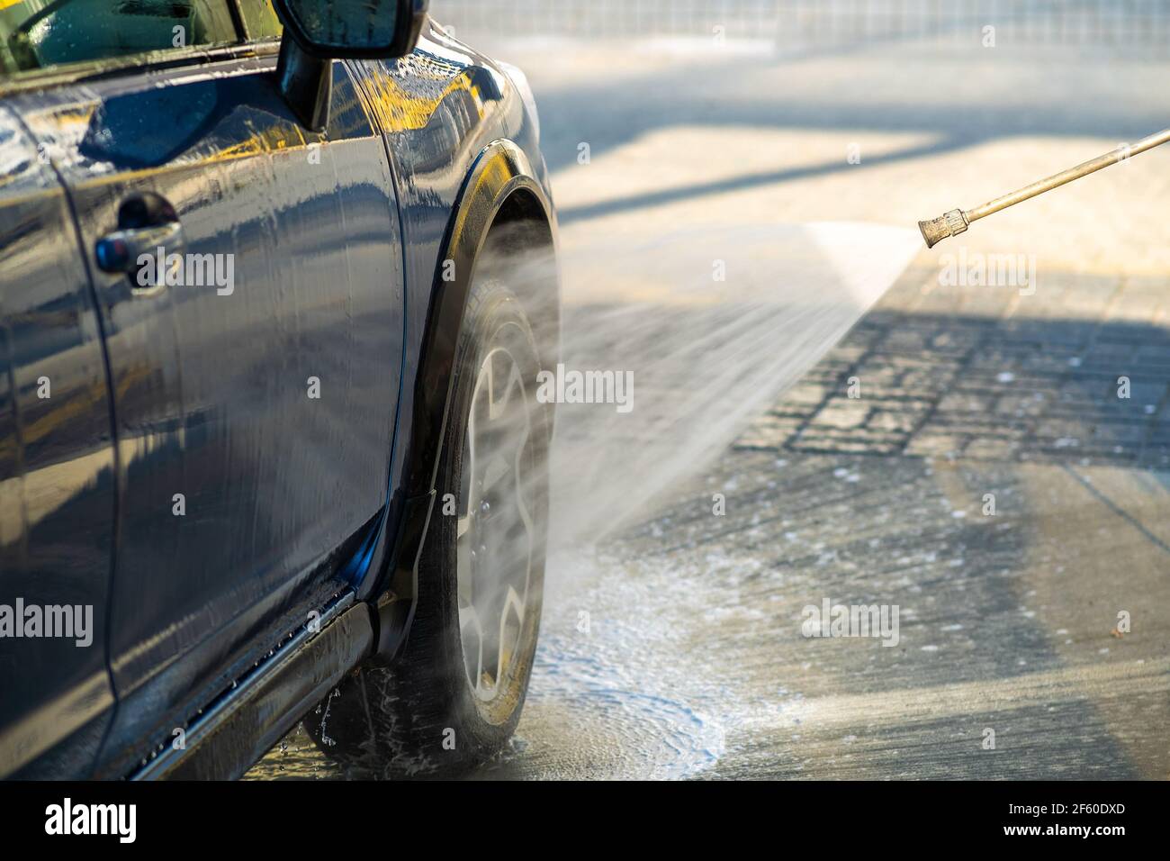 Closeup of male driver washing his car with contactless high pressure ...