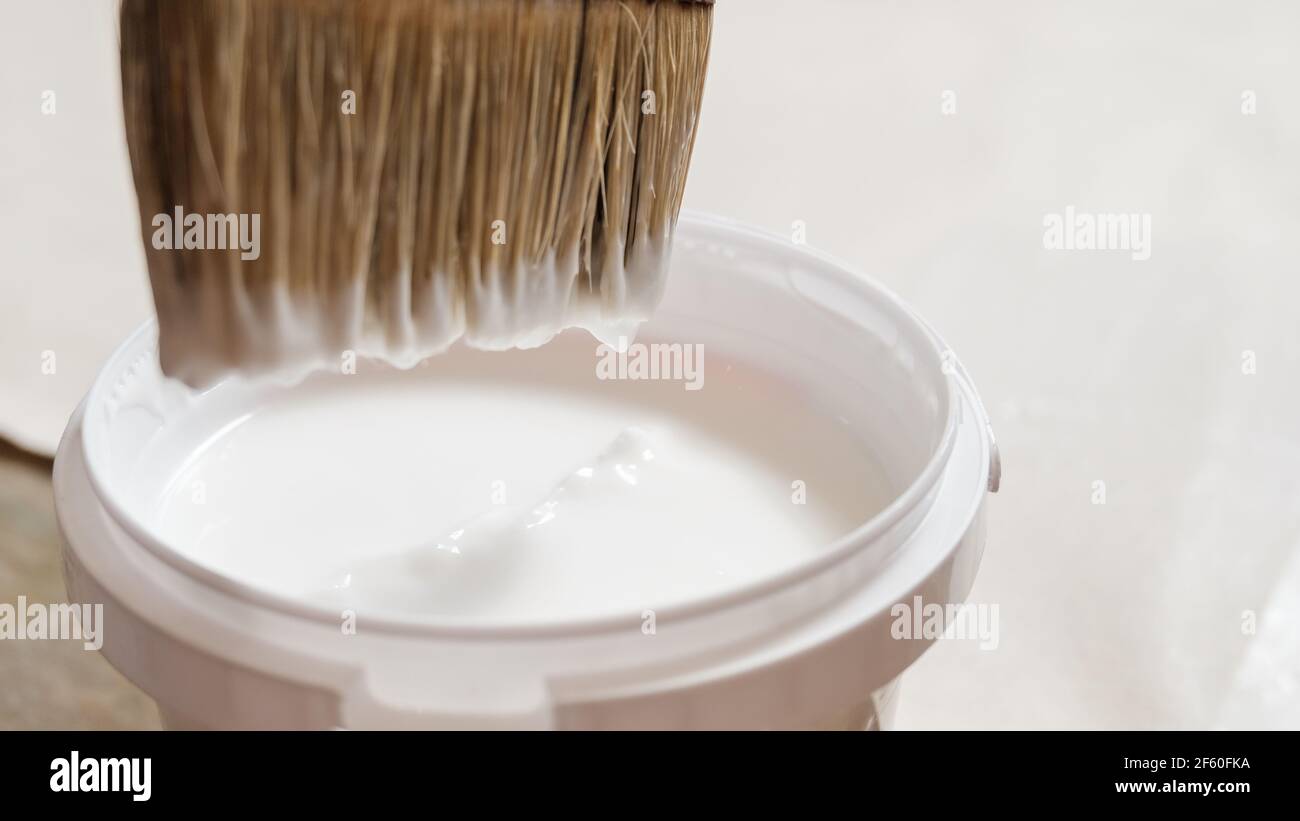 Applying white glue to cotton fabric with a brush Stock Photo - Alamy