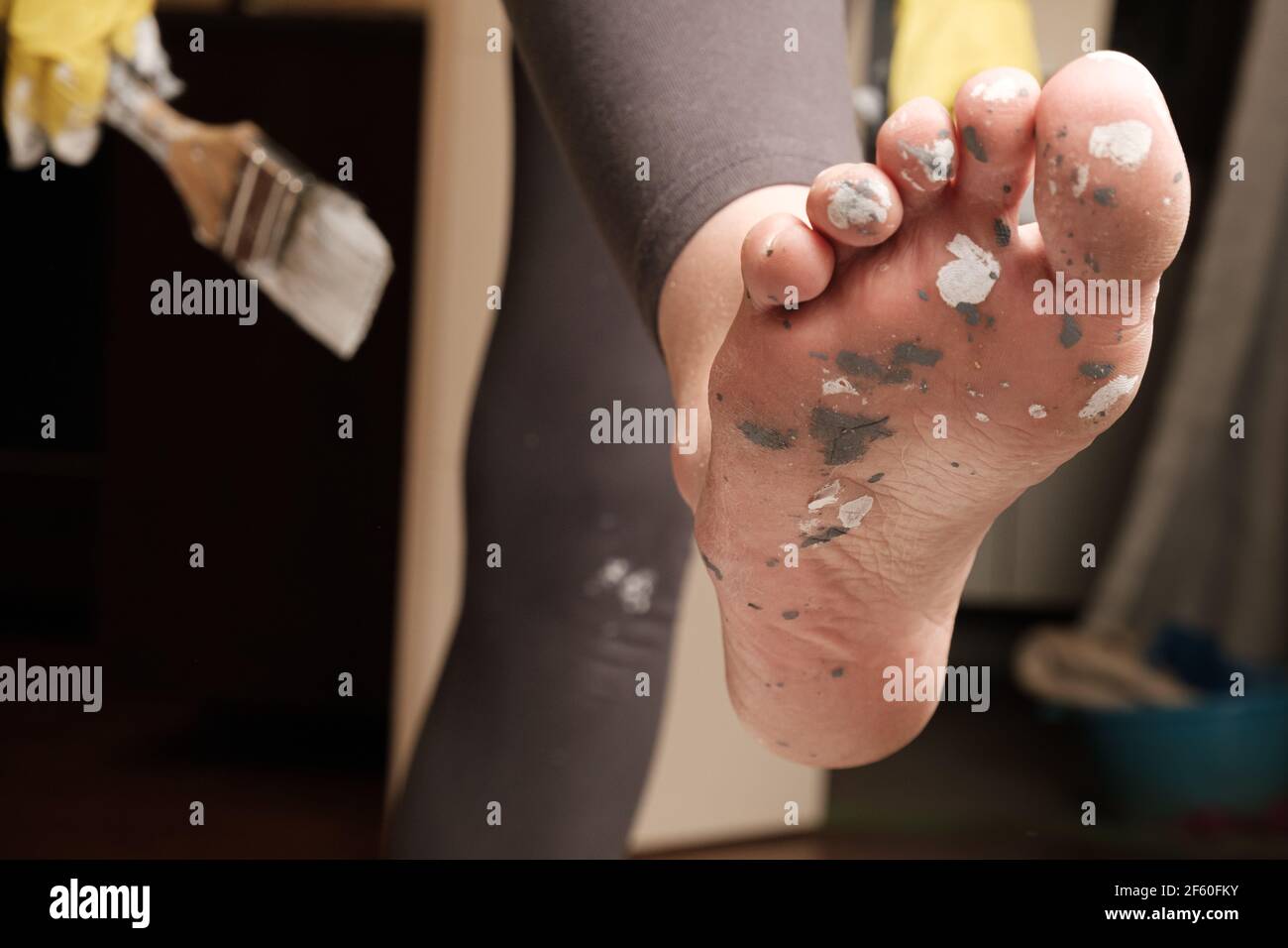 Bare foot in spots of white and gray paint Stock Photo - Alamy