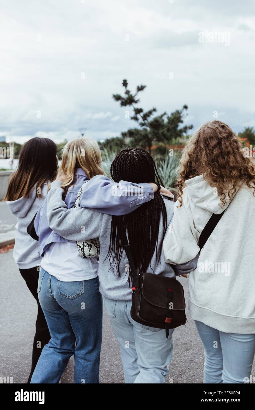 Three friends walking arms around hi-res stock photography and images ...