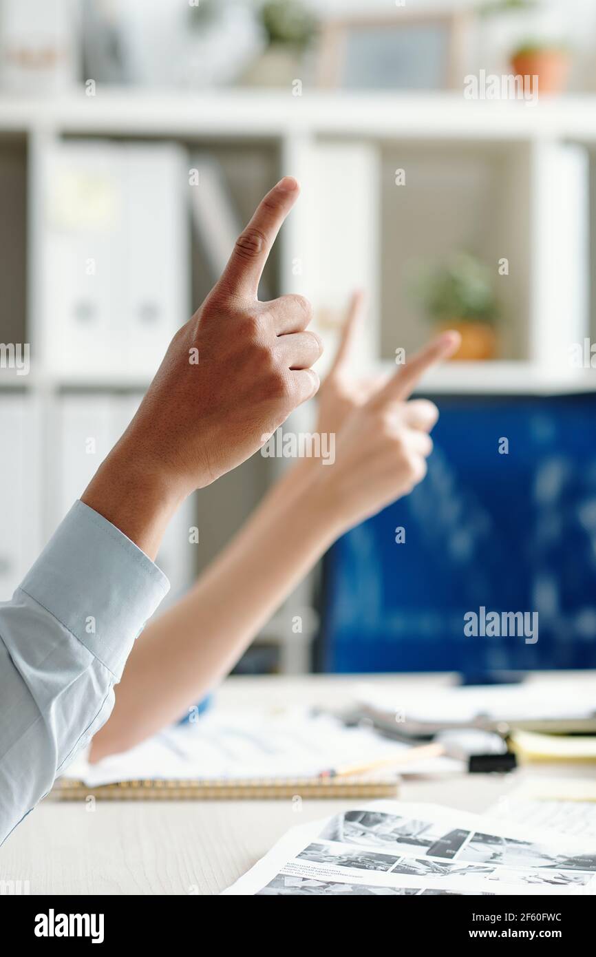 Business people sitting at meeting table and pointing with finger to ...