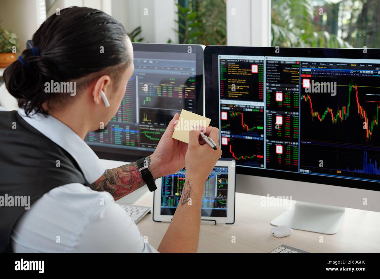Trader looking at stock market charts on computer screens and taking ...