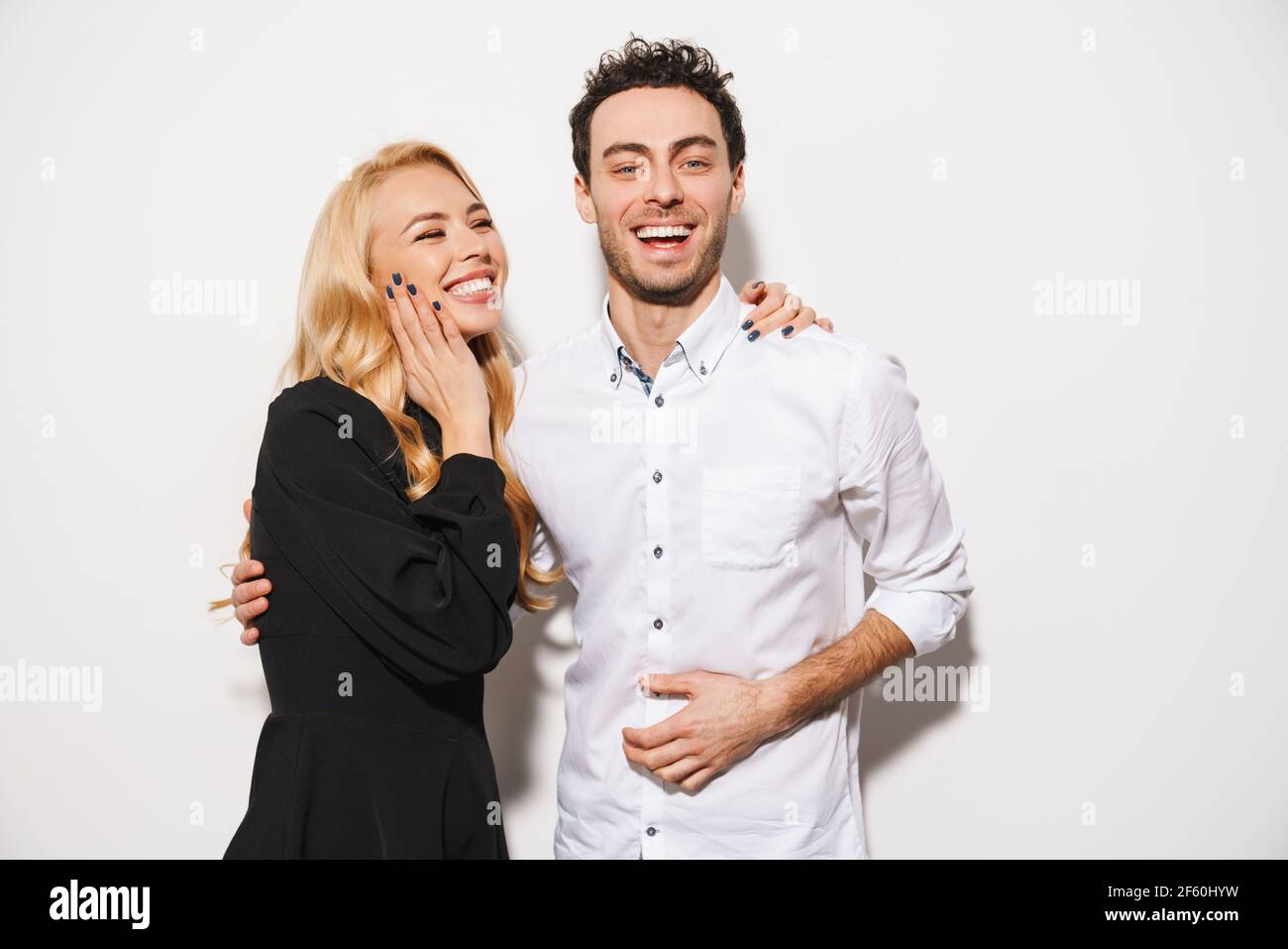 Beautiful smiling young smartly dressed couple standing isolated over ...