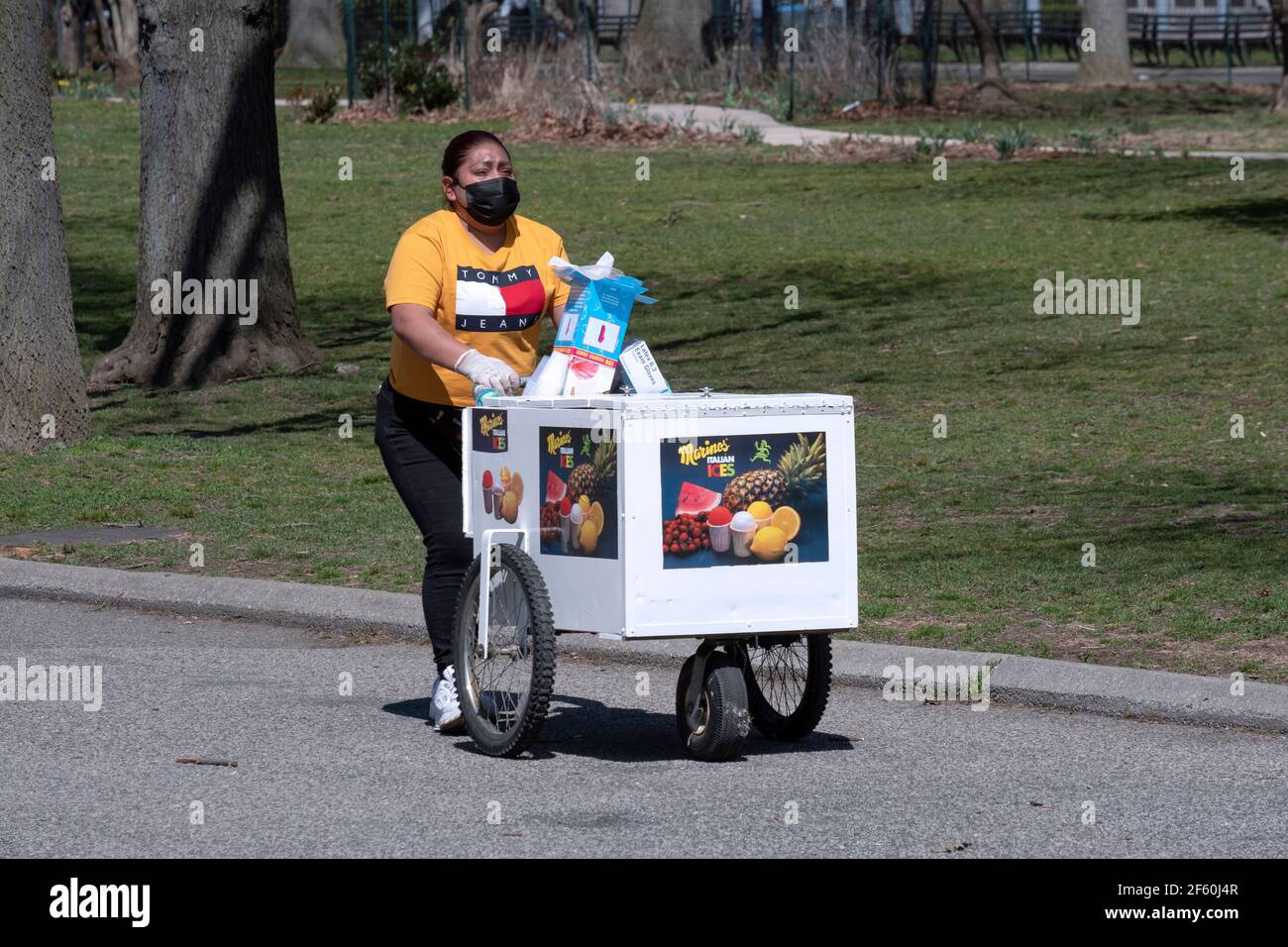 A woman selling Marino's Italian Ices from a 3 wheel cart. On a mild ...
