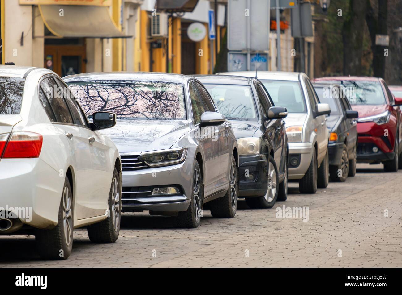 Cars parked in a row on a city street side Stock Photo - Alamy