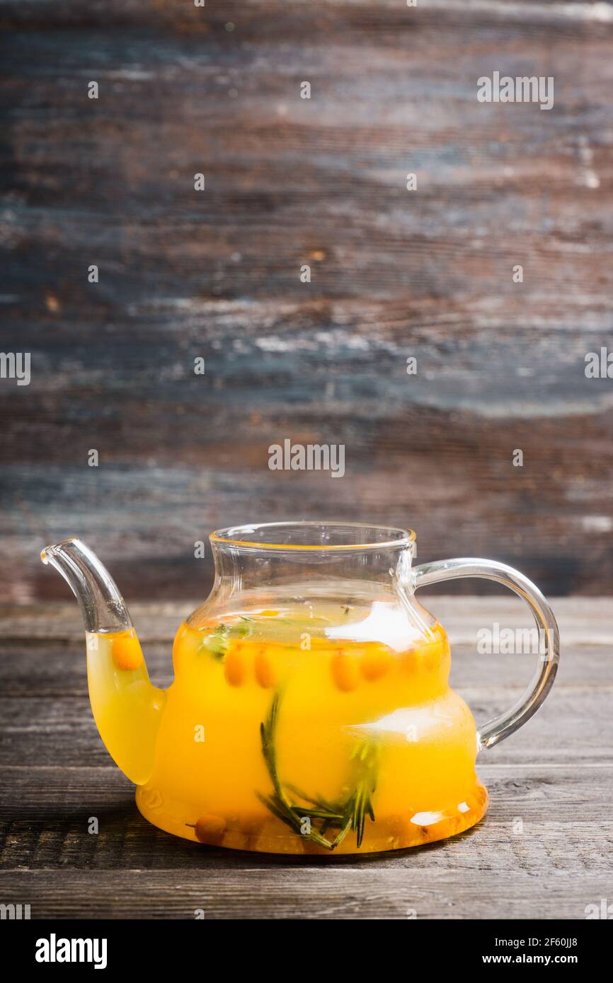 Hot buckthorn beverage in glass teapot. Selective focus. Shallow depth ...